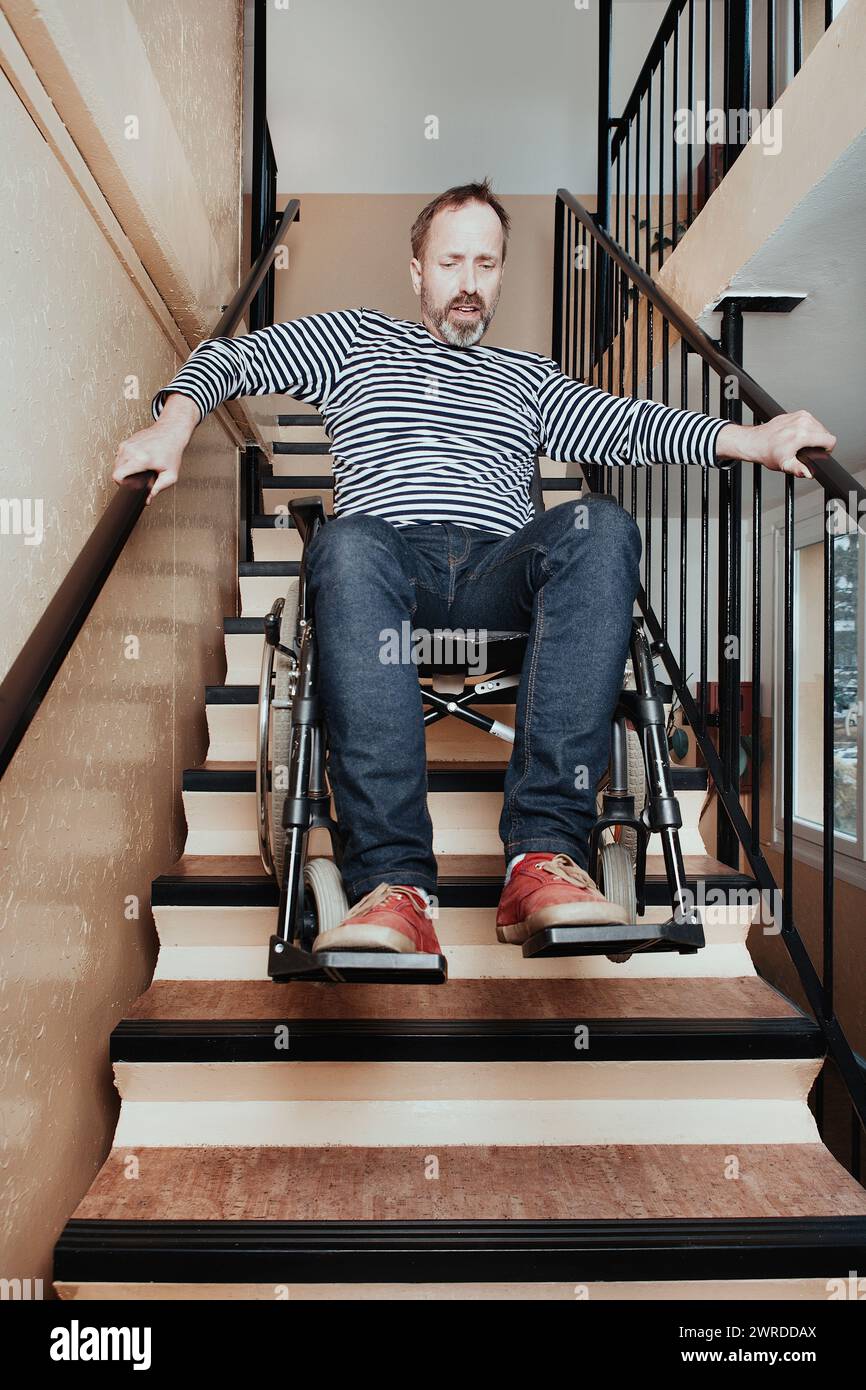 Disabled man on wheel chair riding down the stairs Stock Photo - Alamy