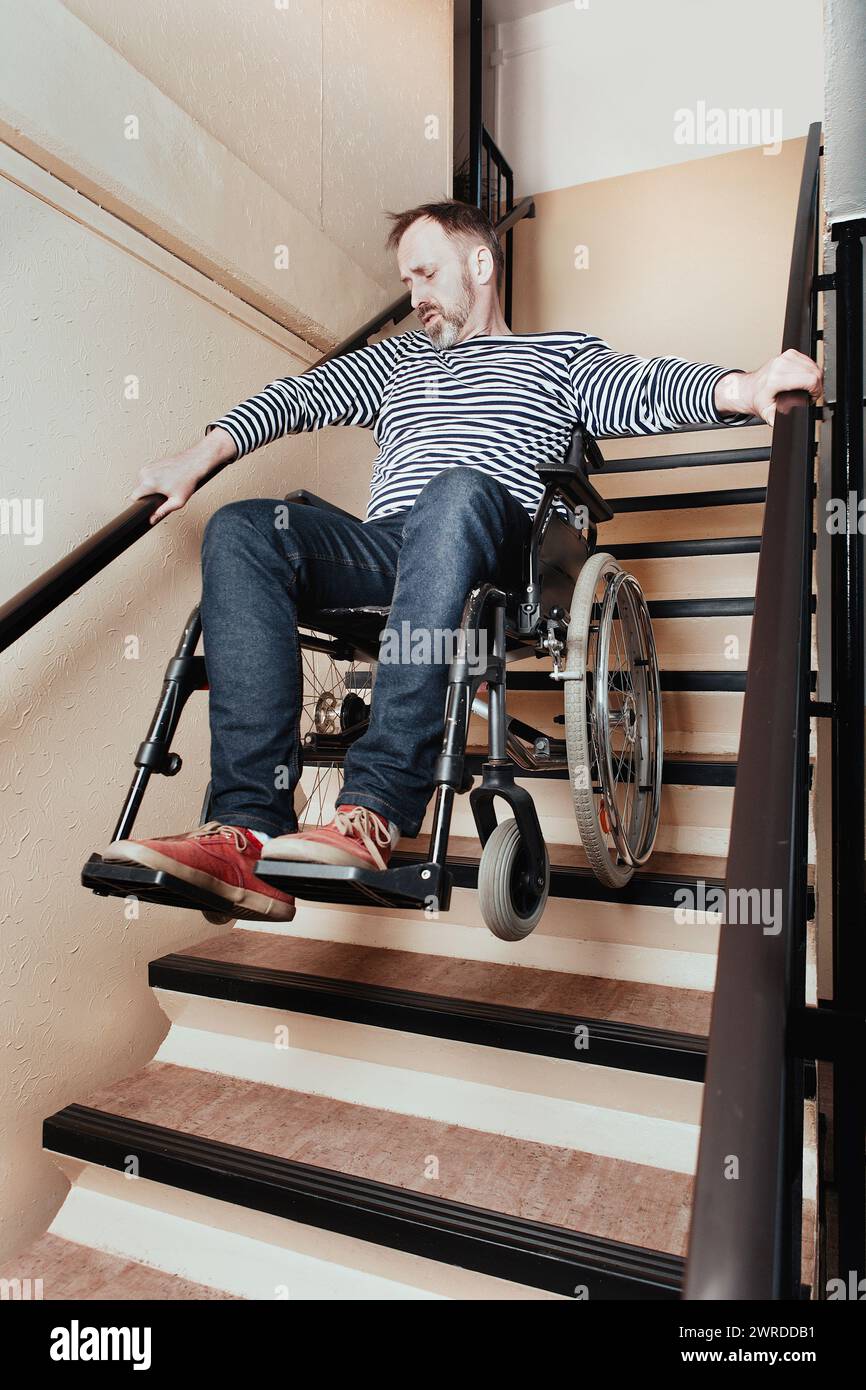 Disabled man on wheel chair riding down the stairs Stock Photo - Alamy