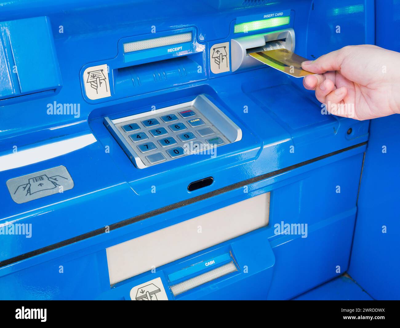 female hand inserting ATM card into ATM bank machine to withdraw money ...