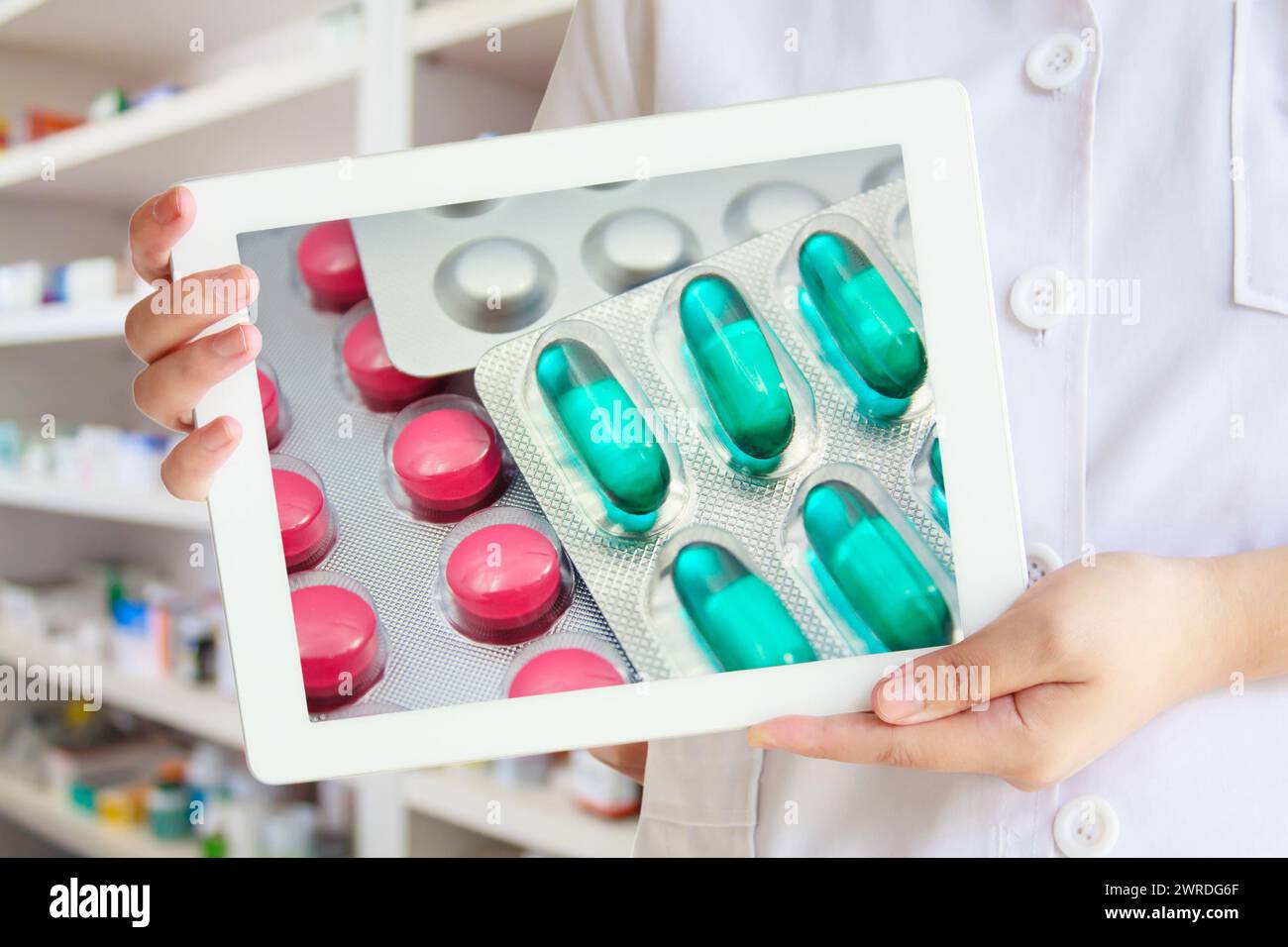 Female pharmacist showing tablet computer with medicine on screen over ...