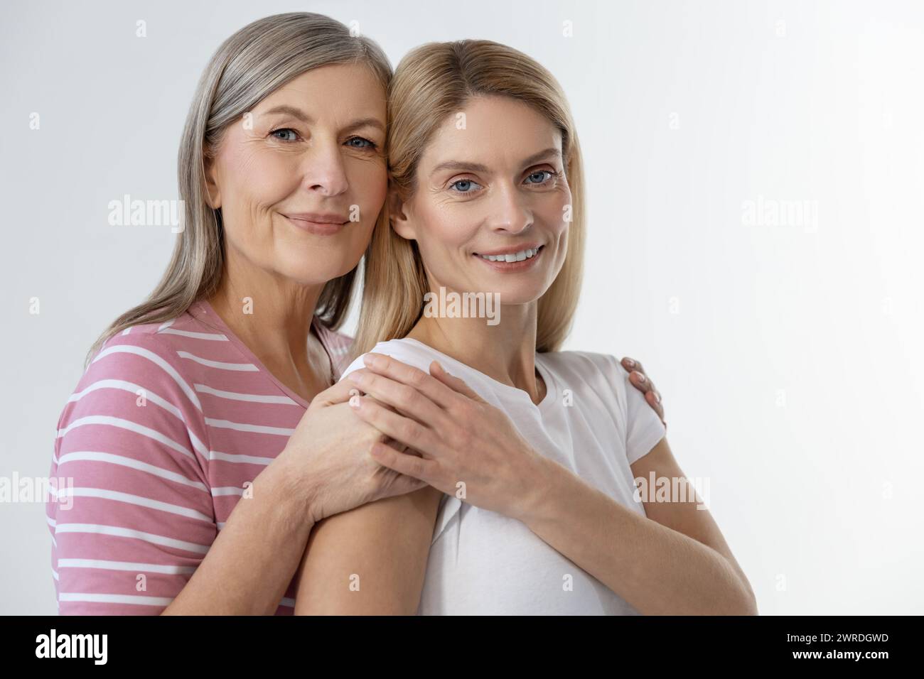 Mom hugging her daughter and smiling happily Stock Photo - Alamy