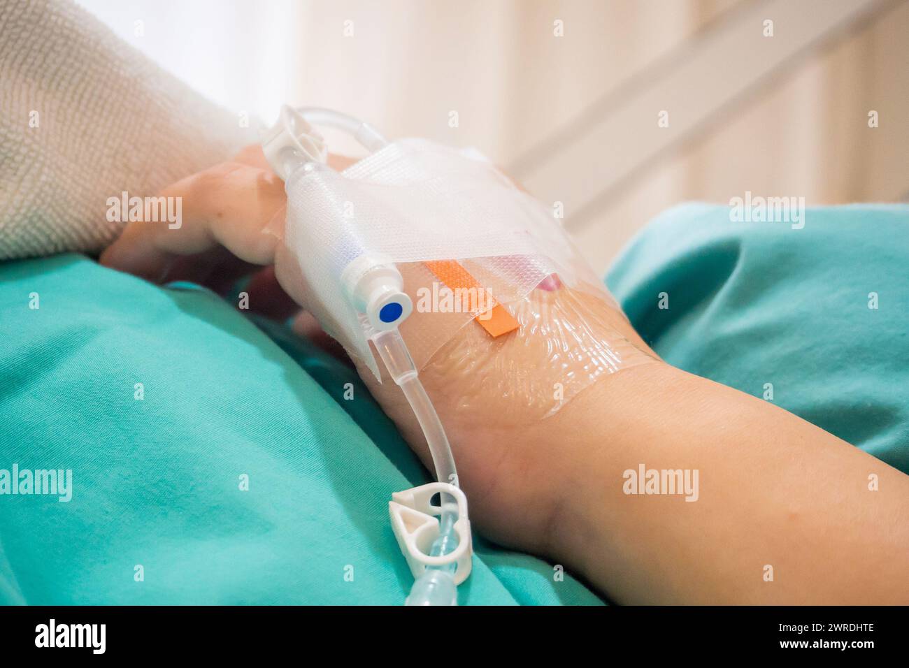 Asian woman patient hand on IV drip with saline solution, fluid ...