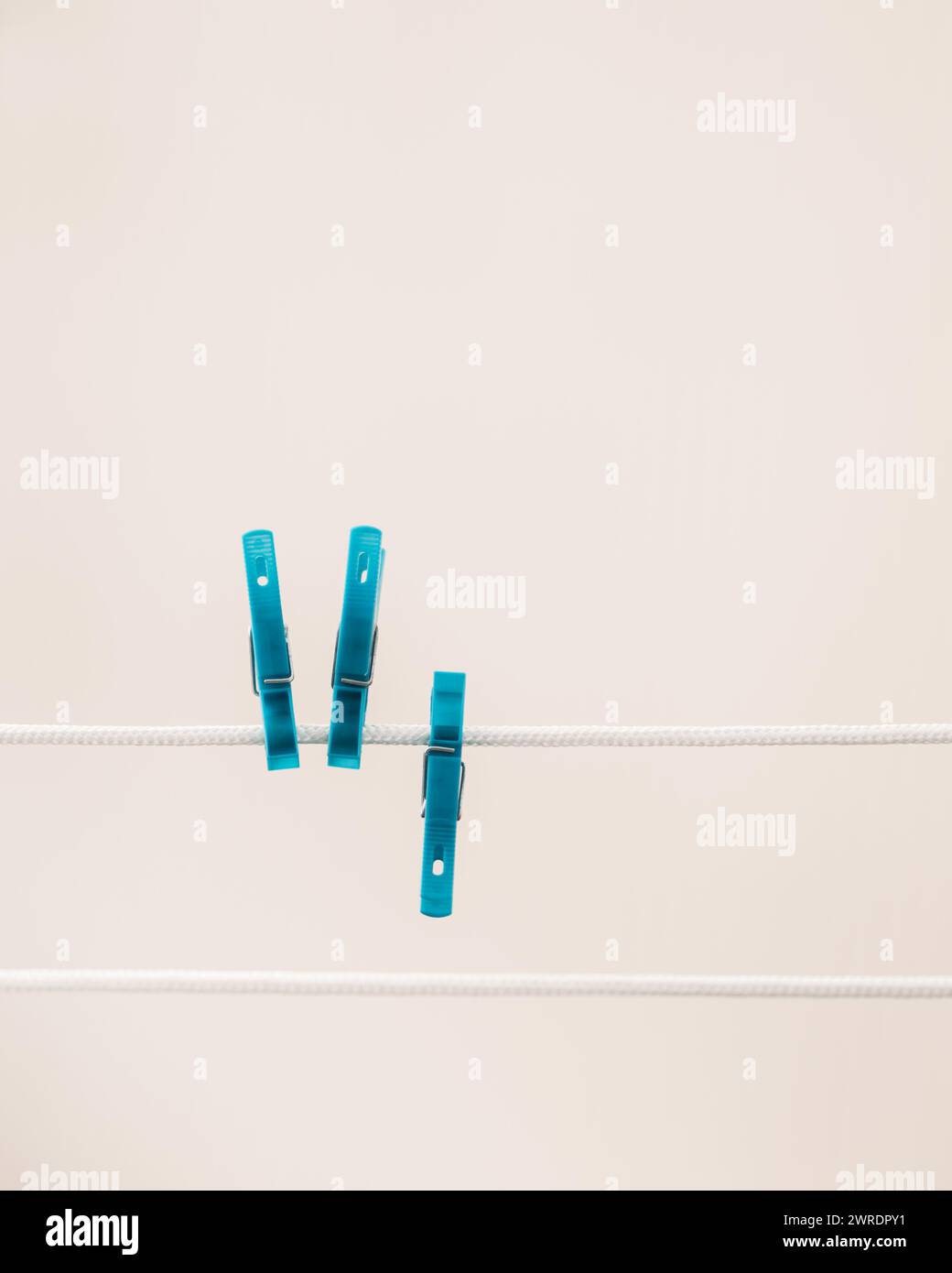 Two Blue Clothespins Are Hanging On A Clothes Line Against White ...