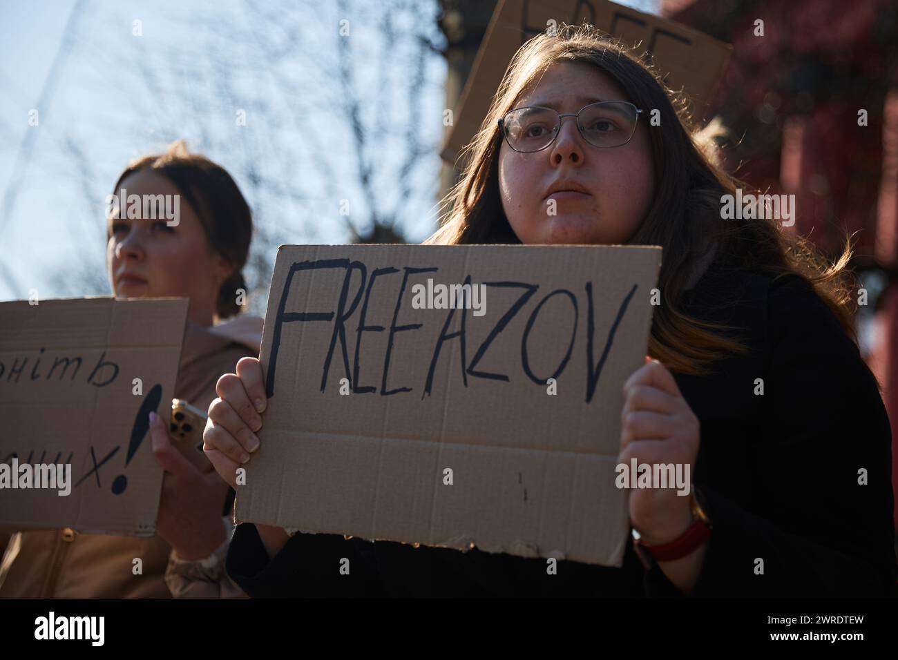 Sad Ukrainian woman holds a banner "Free Azov" on a demonstration for ...