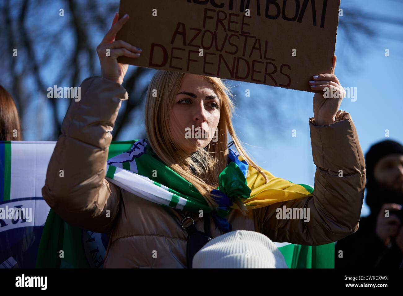 Sad Ukrainian woman holds a banner "Free Azovstal Defenders" on a ...