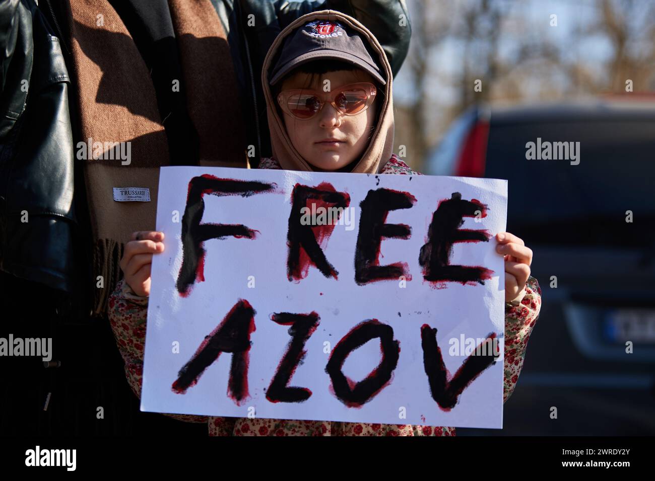 Little Ukrainian girl posing with a banner "Free Azov" on a peaceful ...
