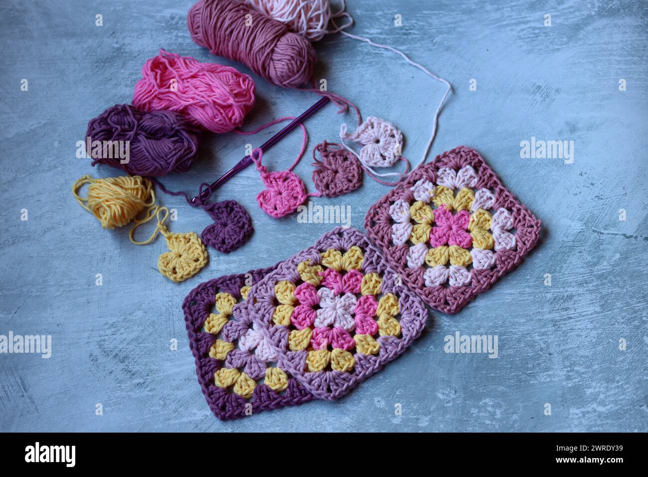 Soft cotton yarn, crochet hook and crochet project in process on grey ...