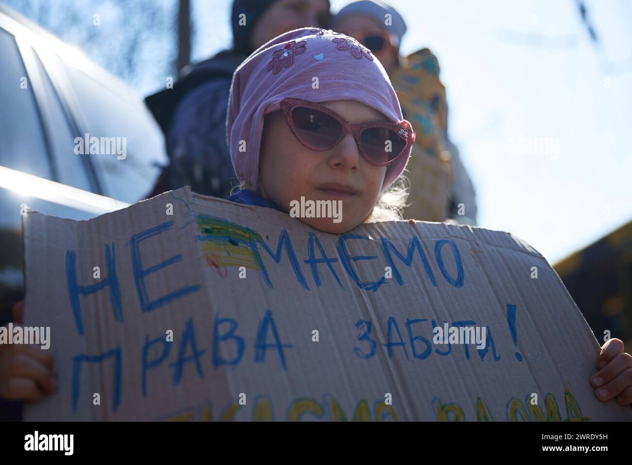 Little Ukrainian girl posing with a banner "We Can't Forget! Free Azov ...
