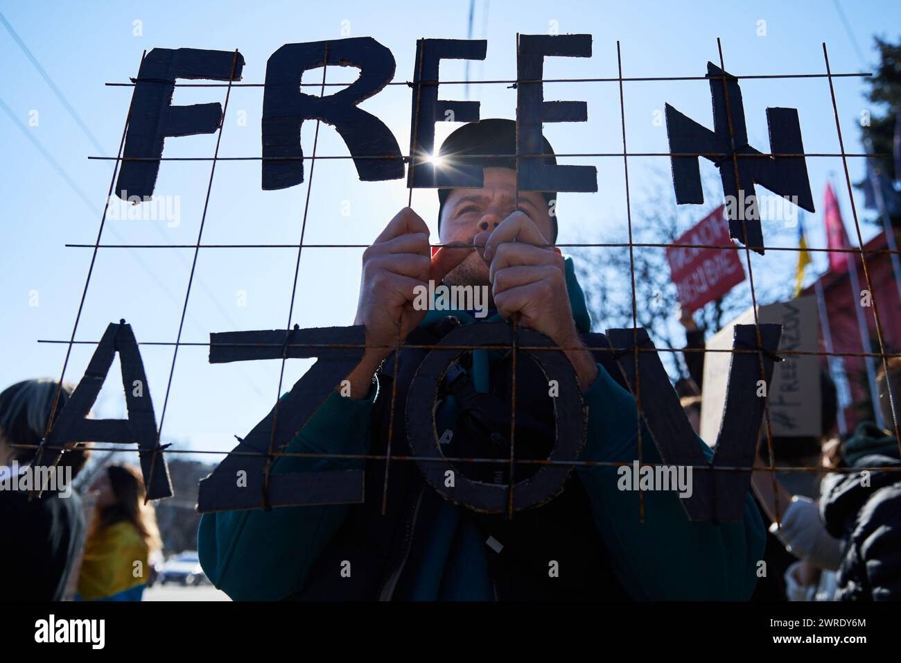 Ukrainian activists posing behind an improvised gate with a writing ...