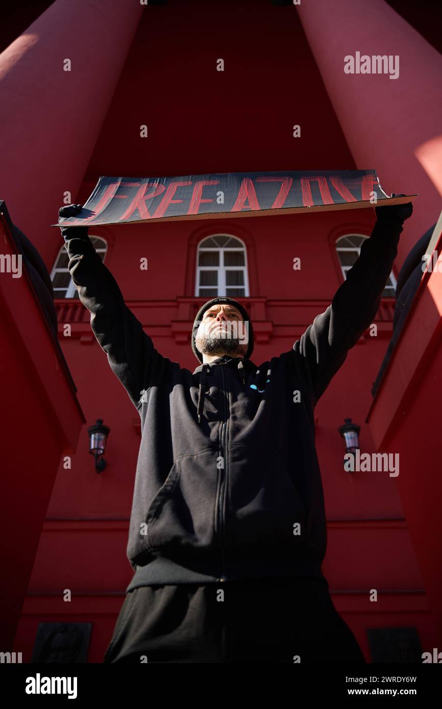 Ukrainian activist posing with a banner "Free Azov" on a public rally ...