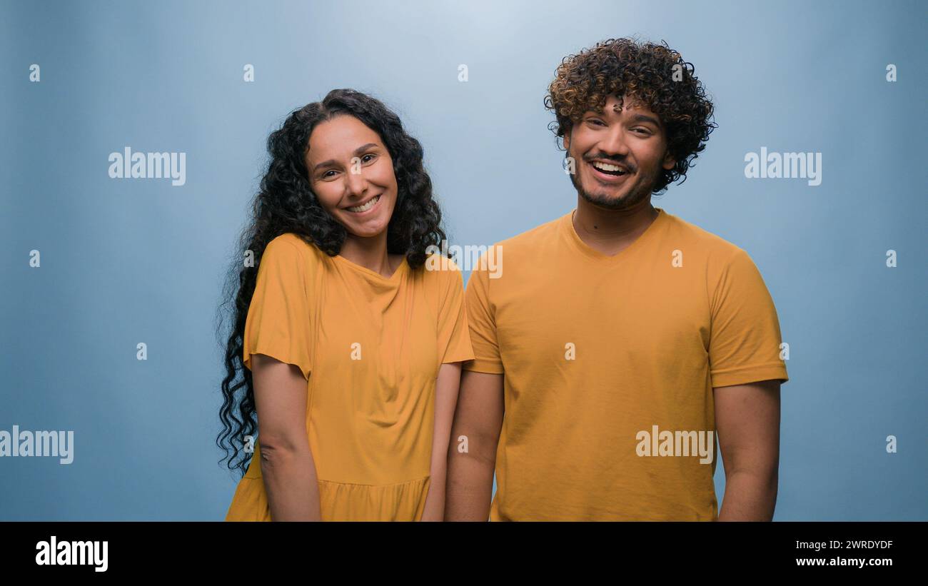 Blue studio background happy multiracial couple showing heart shape St ...