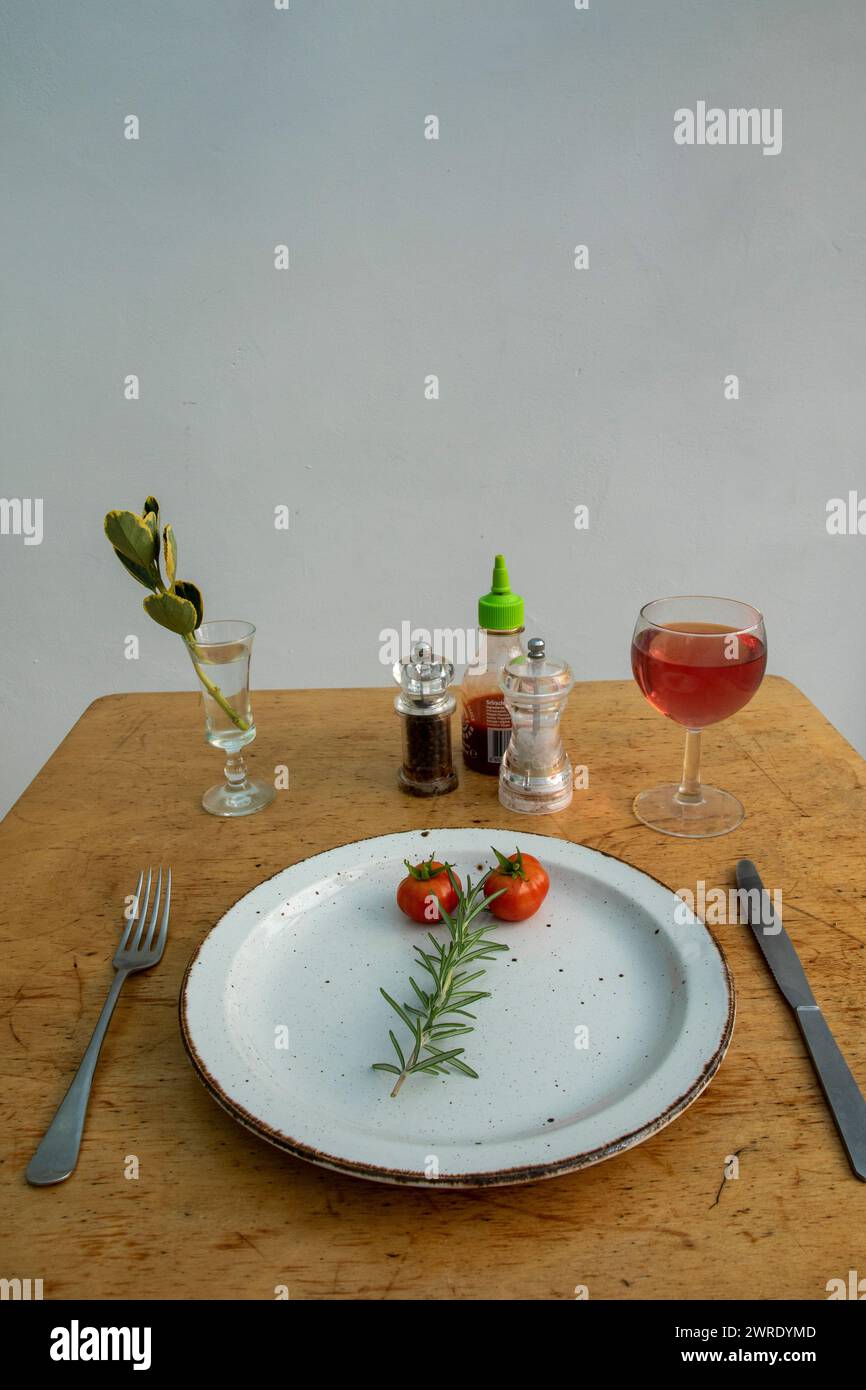 An elegantly simple dinner place setting waiting for the main course to ...