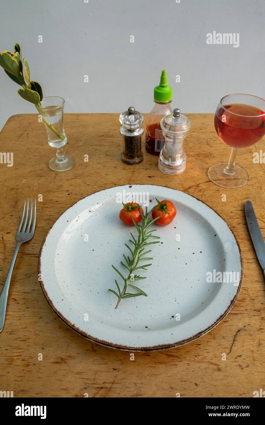 An elegantly simple dinner place setting waiting for the main course to ...