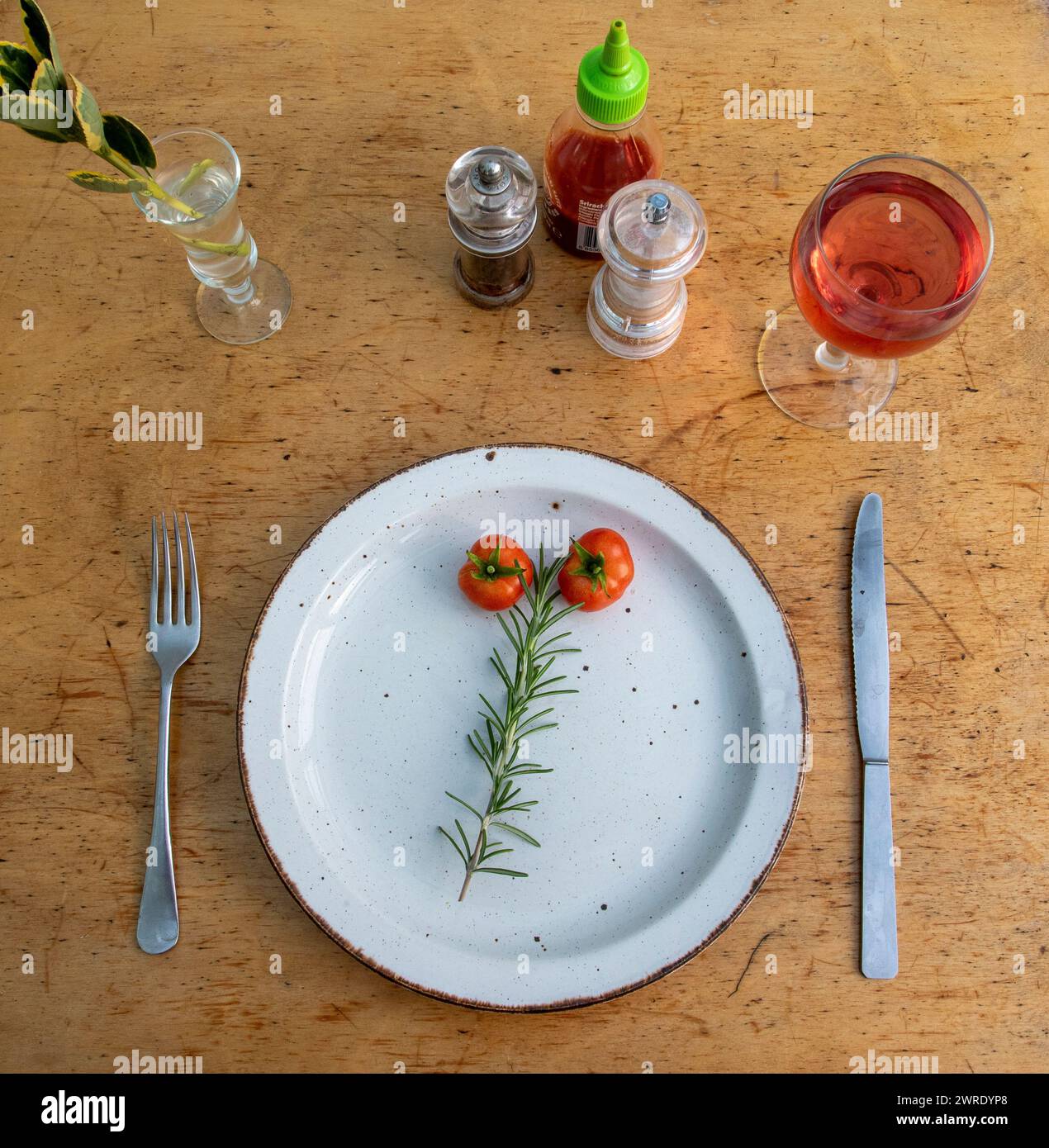 An elegantly simple dinner place setting waiting for the main course to ...