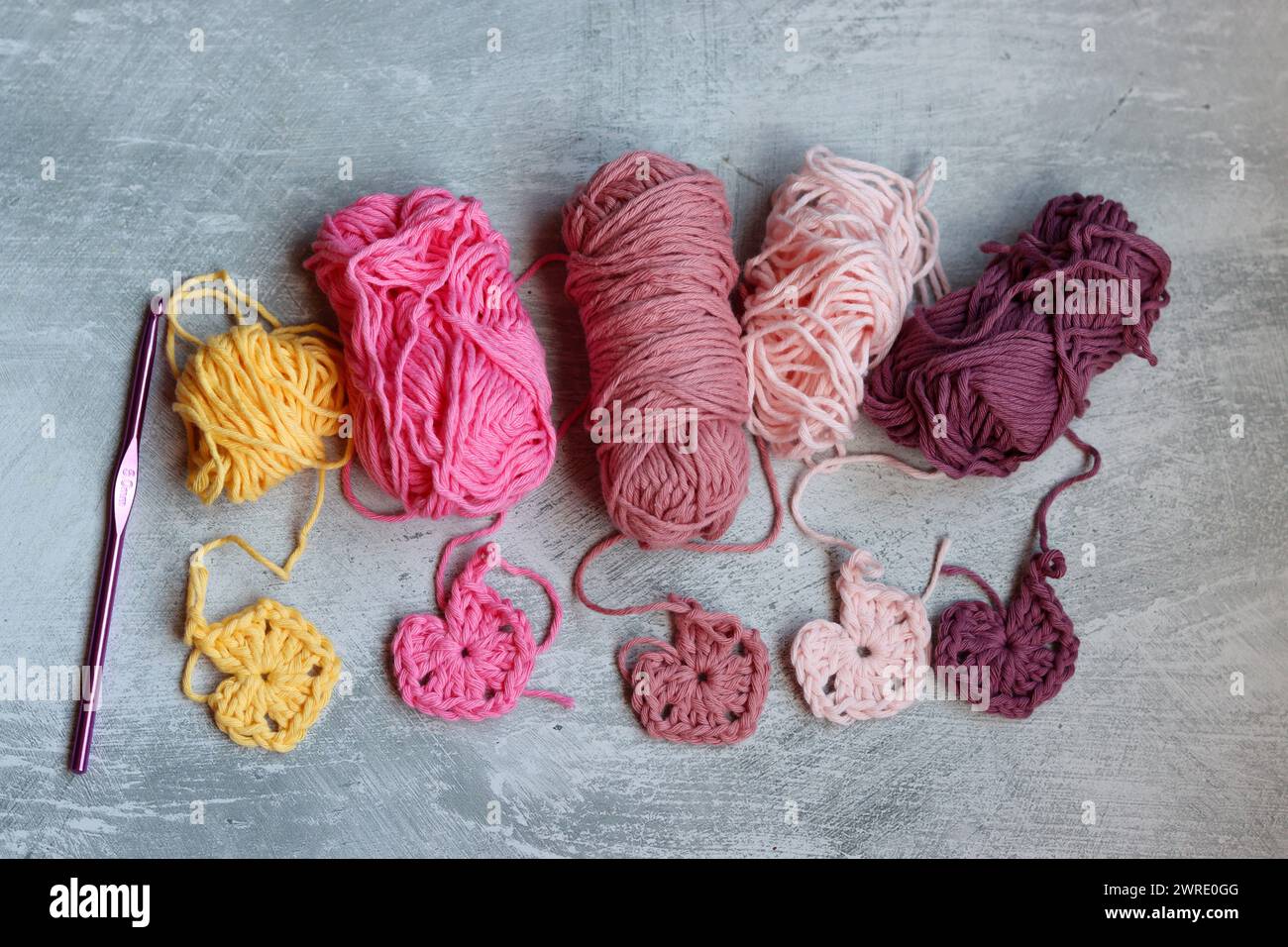 Soft cotton yarn, crochet hook and crochet project in process on grey ...