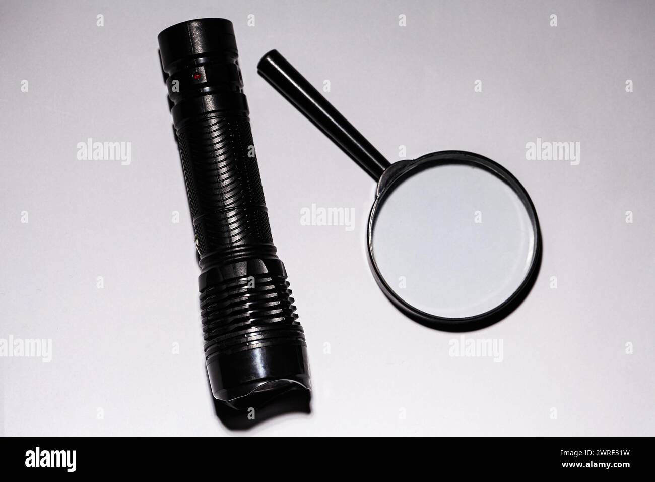 The picture shows a magnifying glass and a flashlight, which is ...