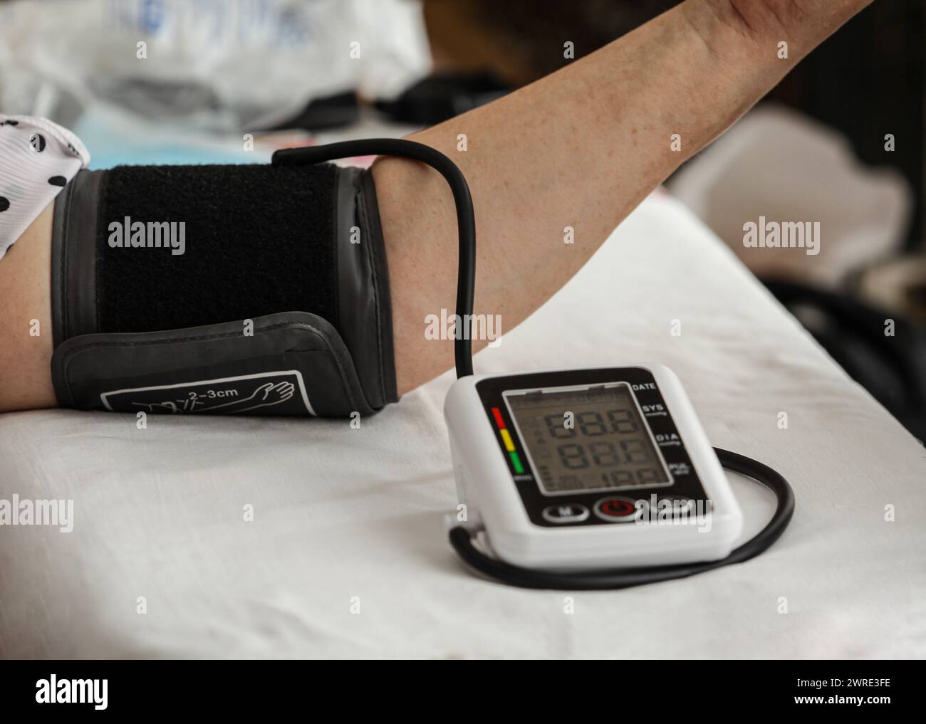 White electric tonometer on white table for measuring blood pressure ...