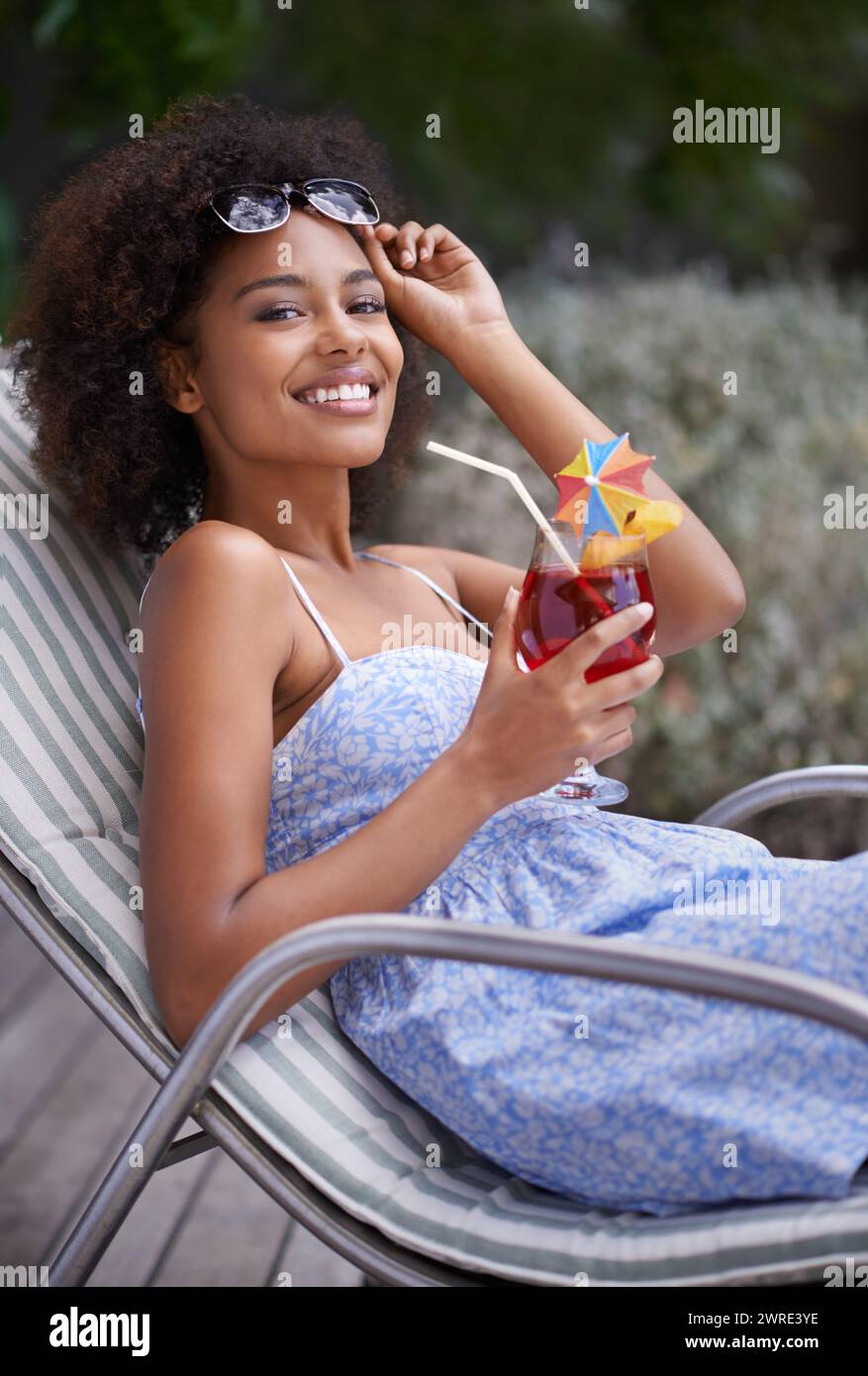 African, woman and sunbathing with cocktail for summer on vacation ...