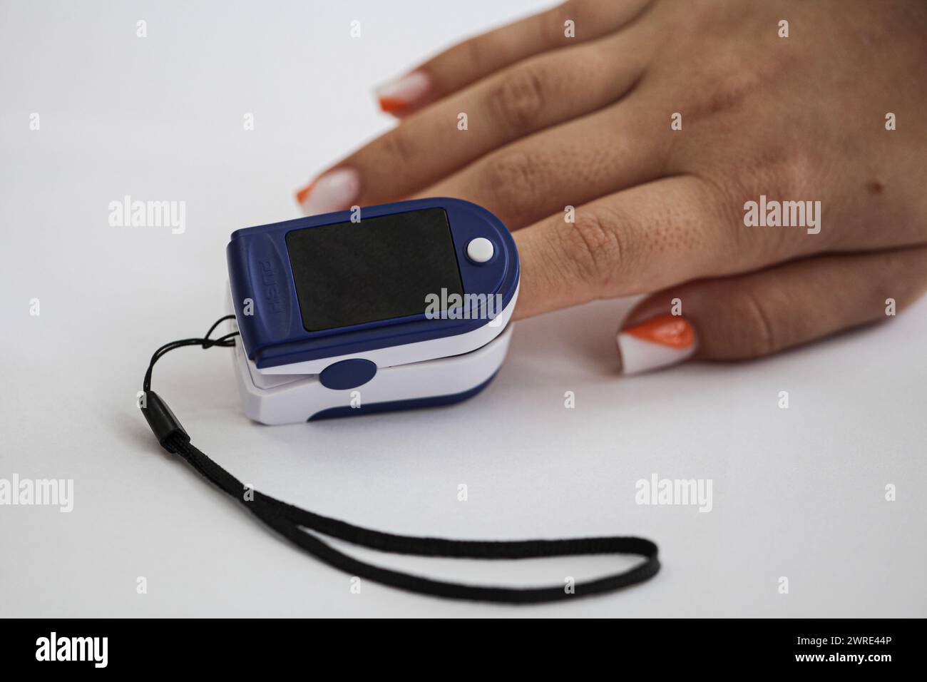The hand of a young man with a pulse oximeter on his finger. Monitoring ...