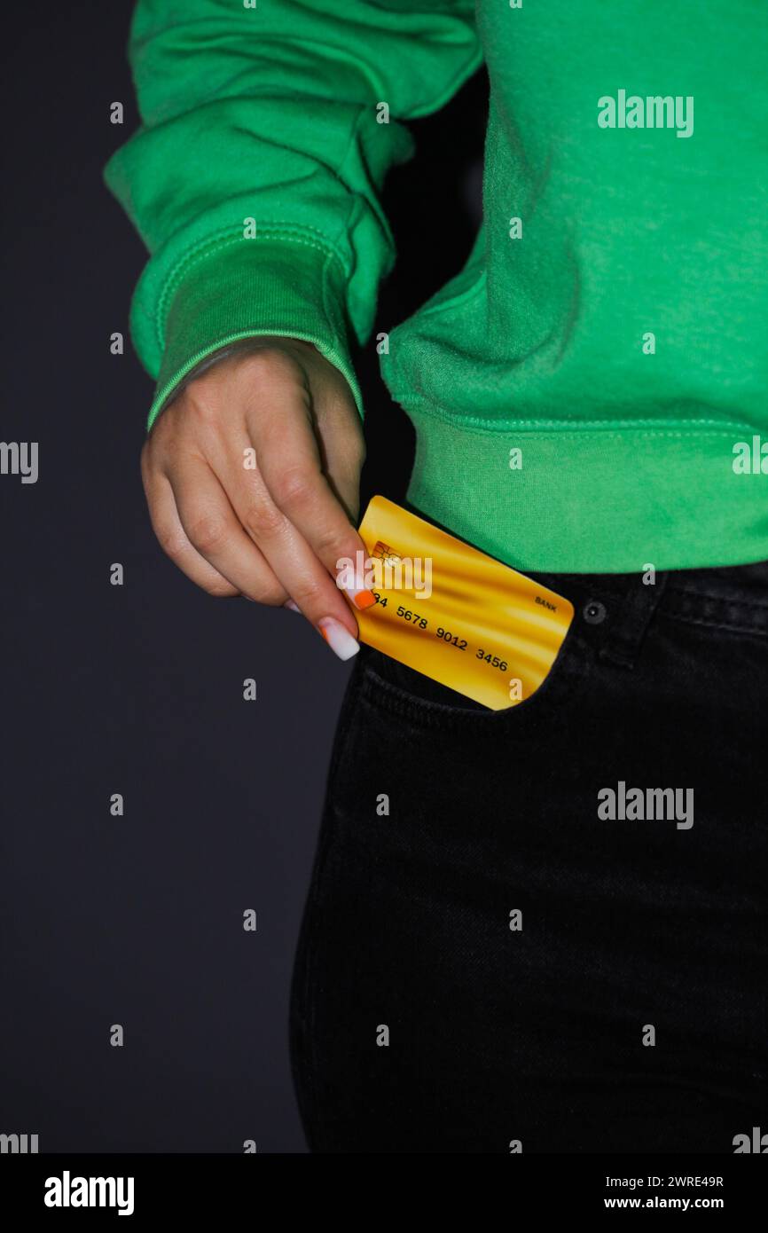 The picture shows a young lady who is ready to put a gold-colored bank ...
