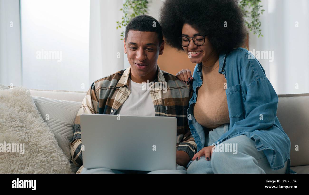 Happy family couple African American husband wife on sofa man woman at ...