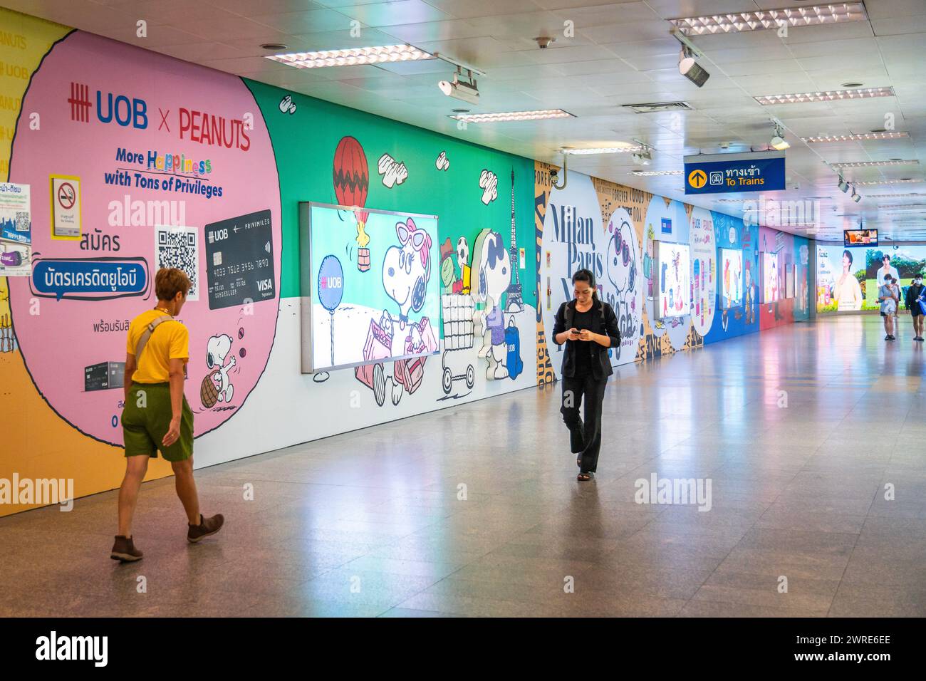 Subway passengers are seen passing by the mural Snoopy and Friends Art ...