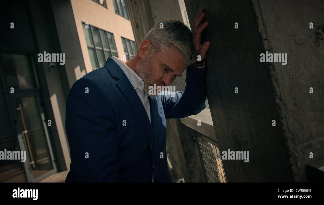 Exhausted stressed tired mature business man dizziness vertigo leaning ...