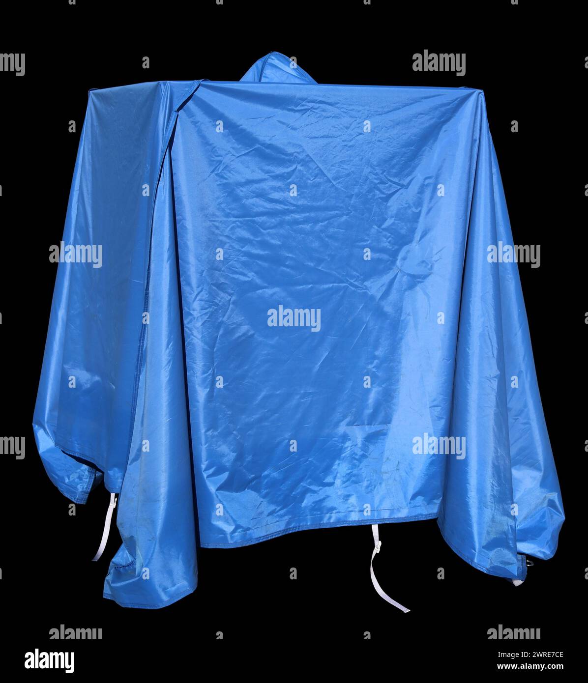 A rectangular object is covered with a thick blue tarpaulin. Isolated ...