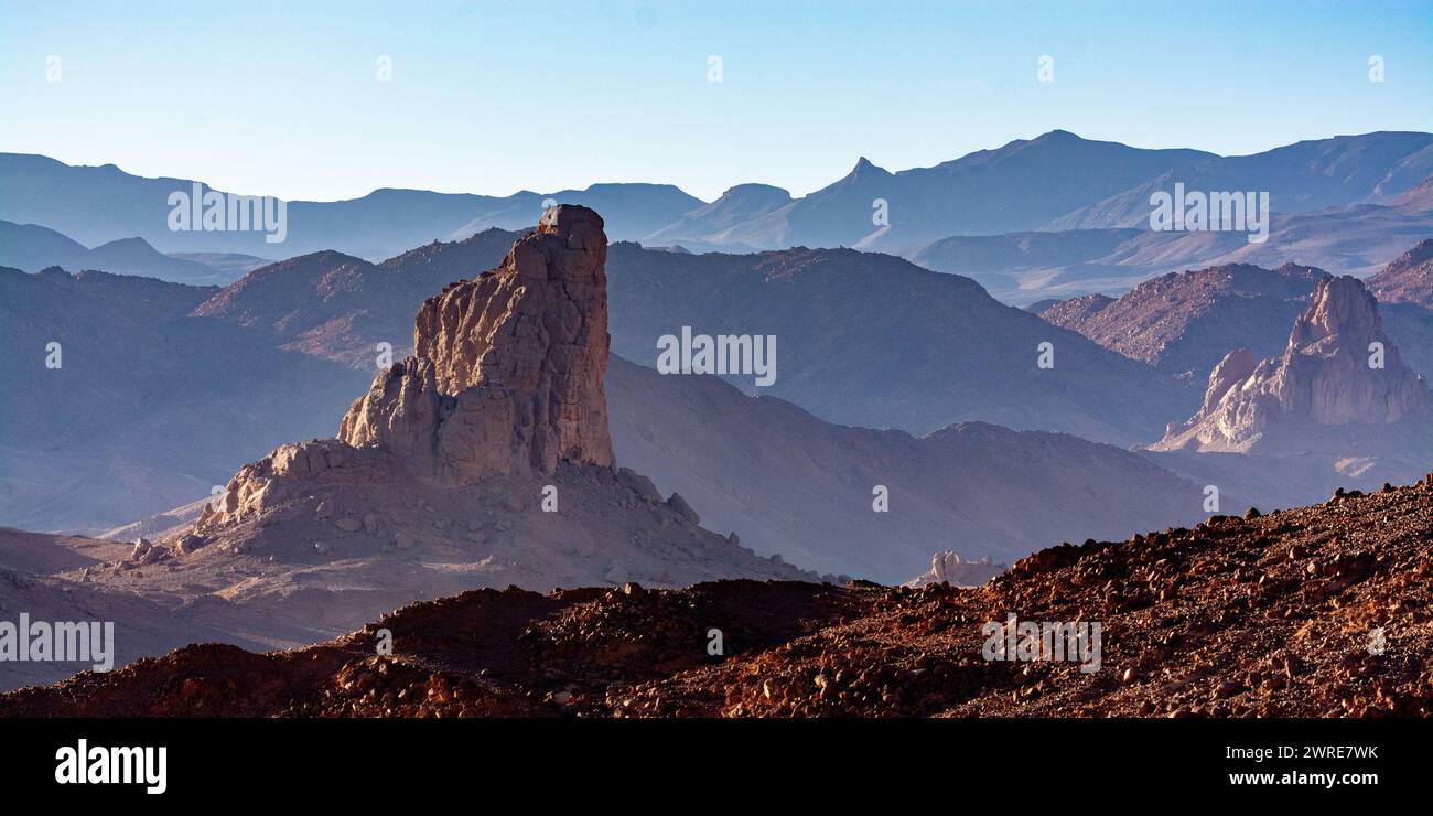 Hoggar landscape in the Sahara desert, Algeria. Steep peaks rise up in ...