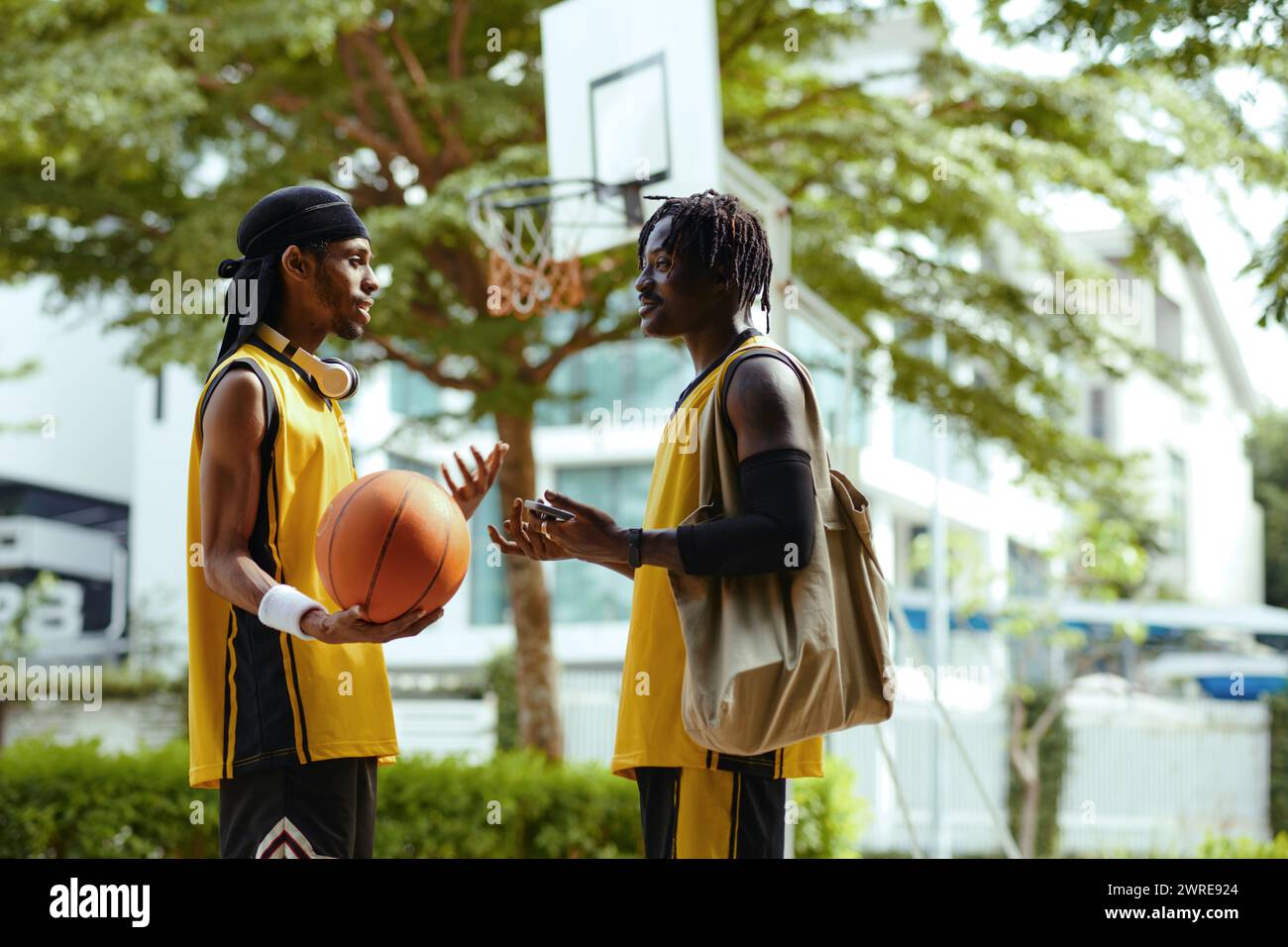 Cheerful friends talking after game of streetball Stock Photo - Alamy