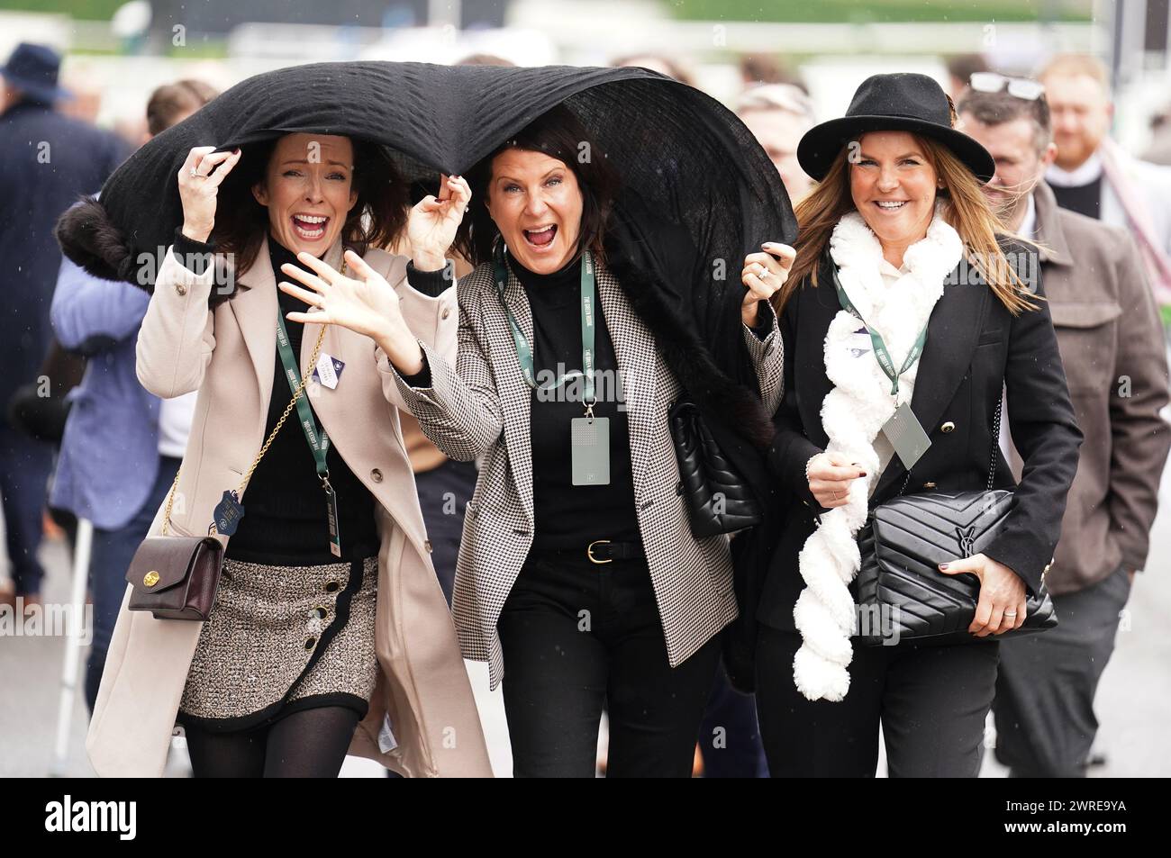 Racegoers shelter from the rain on day one of the 2024 Cheltenham ...