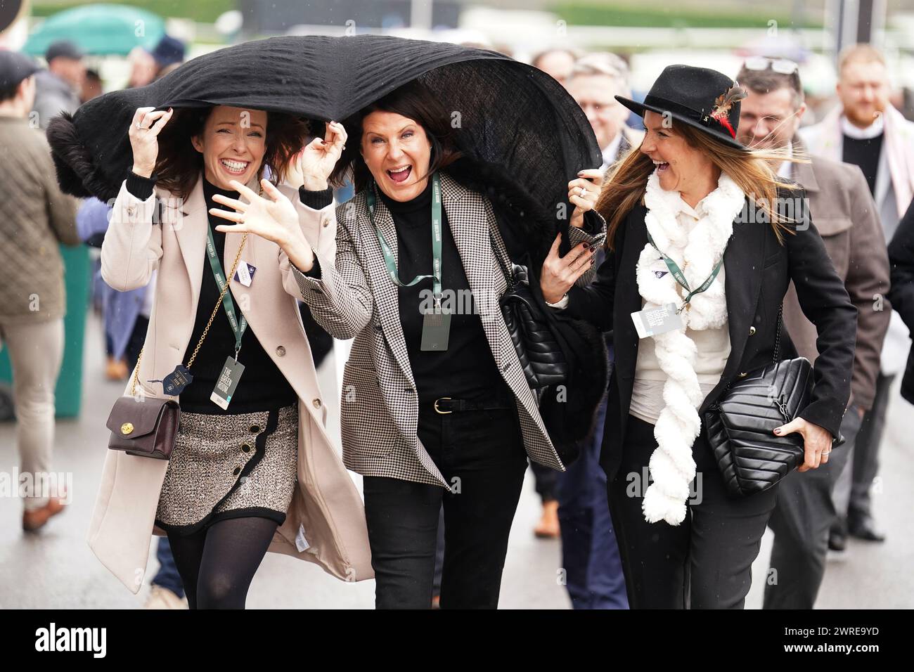Racegoers shelter from the rain on day one of the 2024 Cheltenham ...
