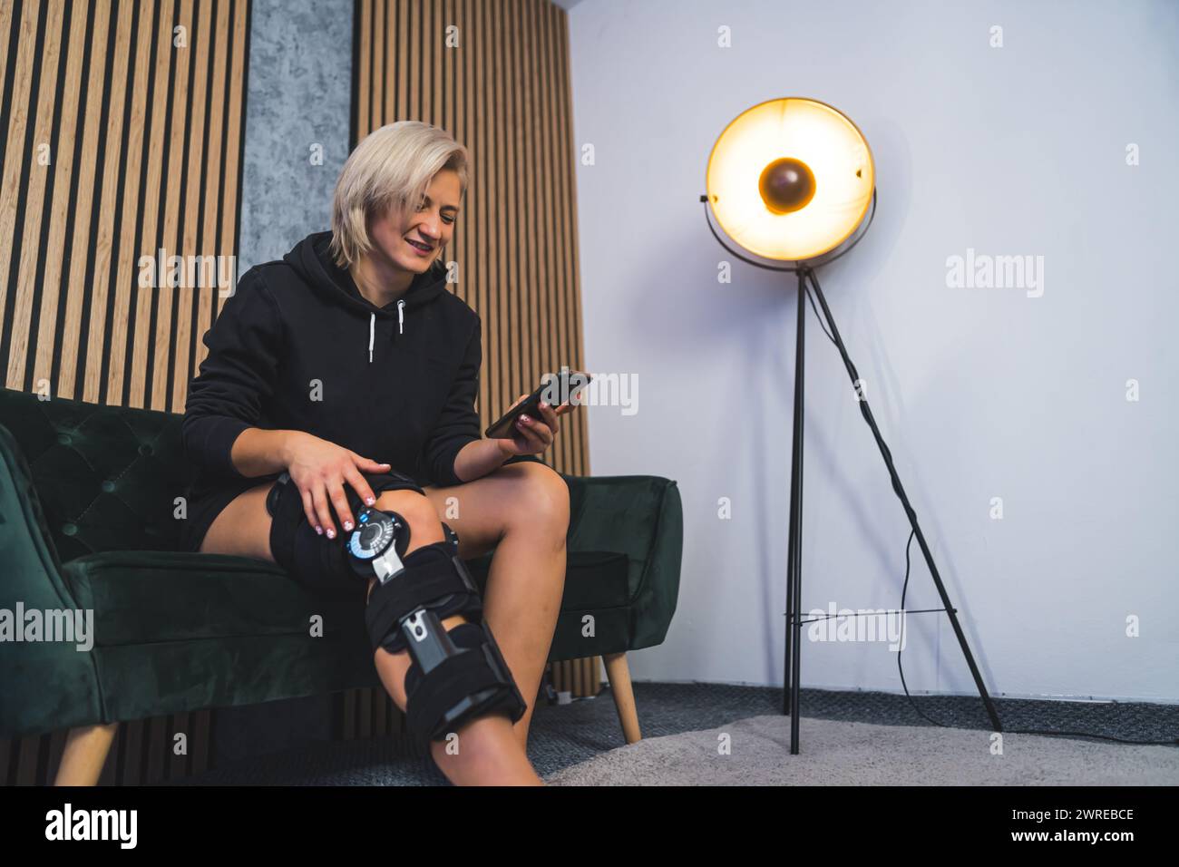 a young woman recovering from injuries at home, wearing a modern knee ...
