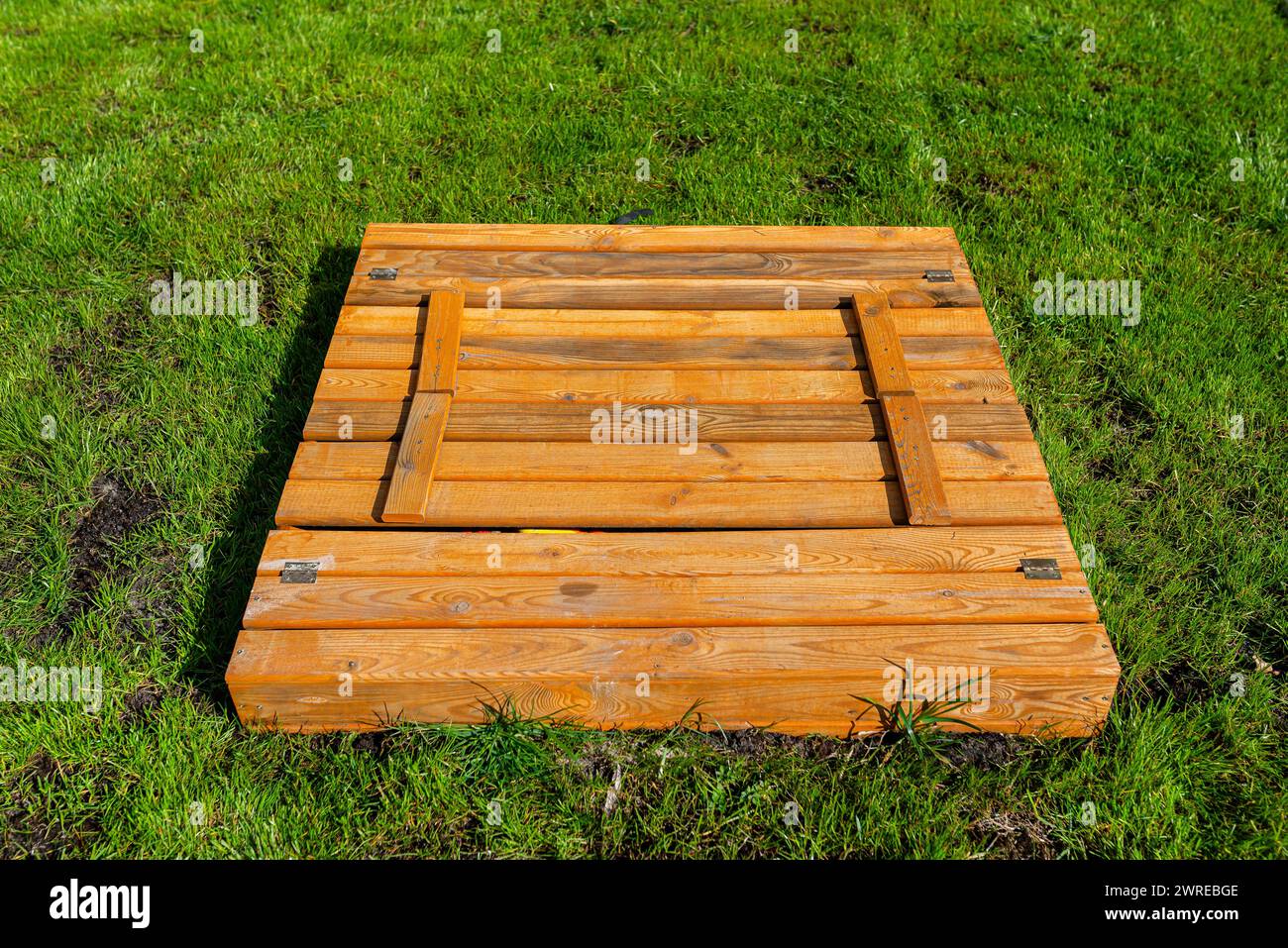 A square-shaped playground made of a wooden closed box, the box is ...