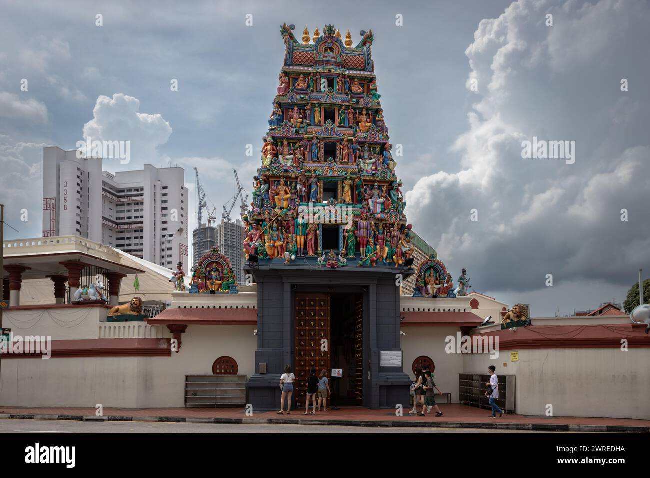 A compact Hindu temple stands in the heart of a busy street Stock Photo ...
