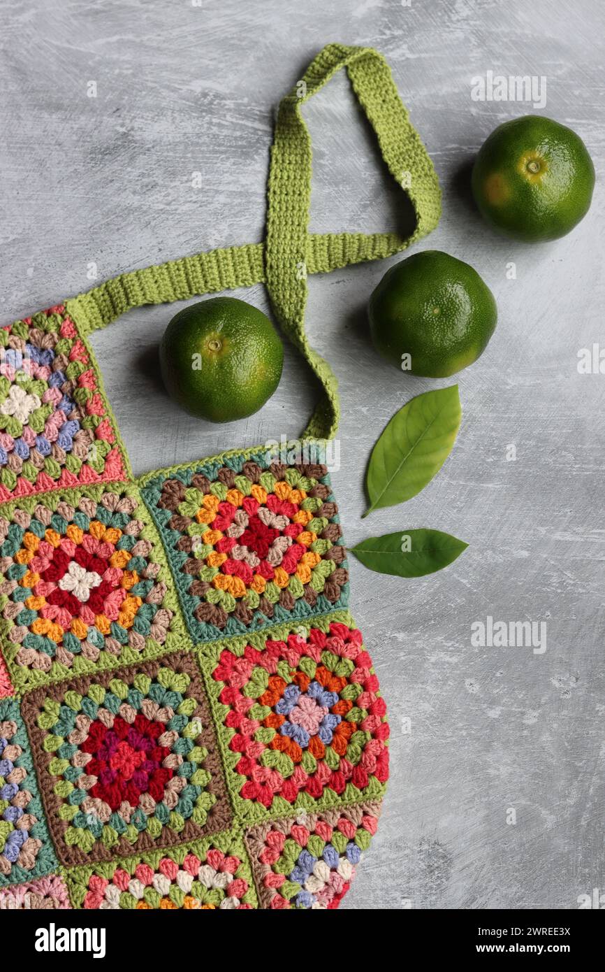 Handmade crocheted bag on grey textured background, top view. Close up ...