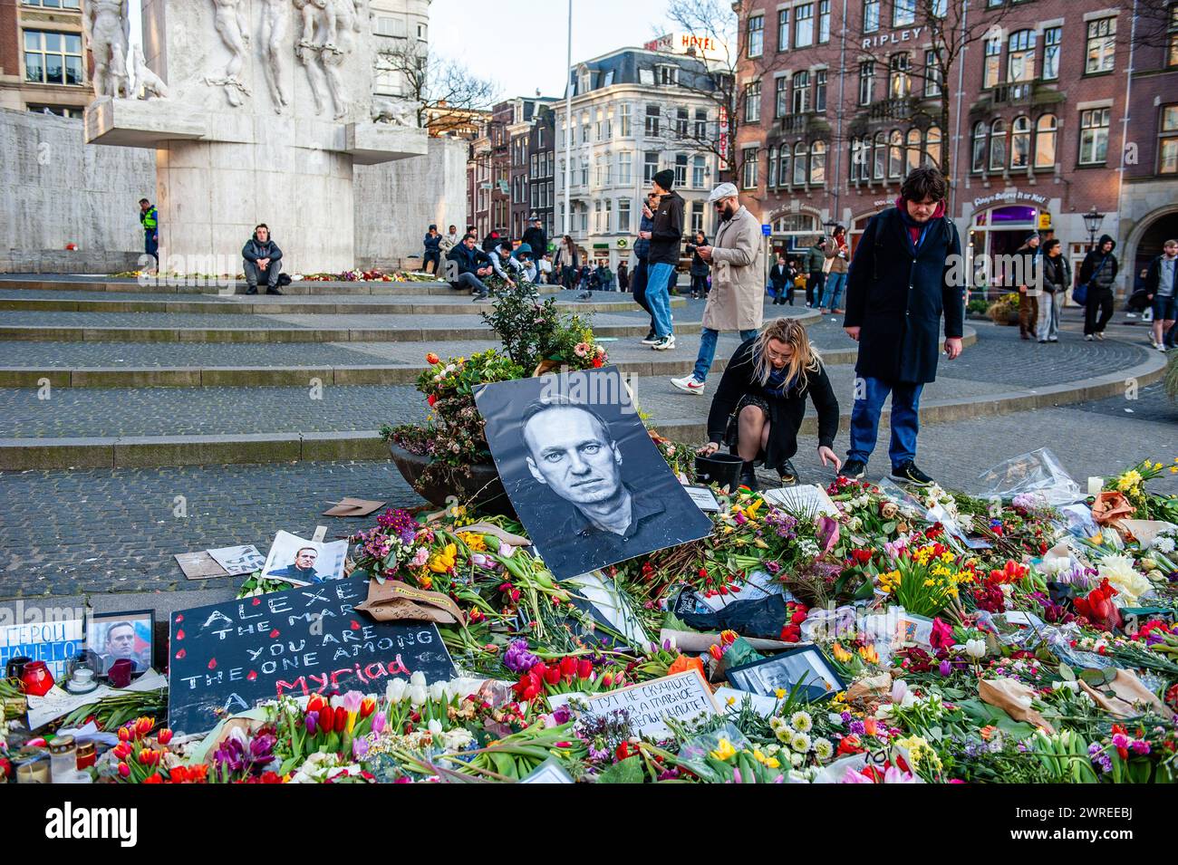 A couple is seen fixing the flowers in Alexei Navalny's memorial. Three ...