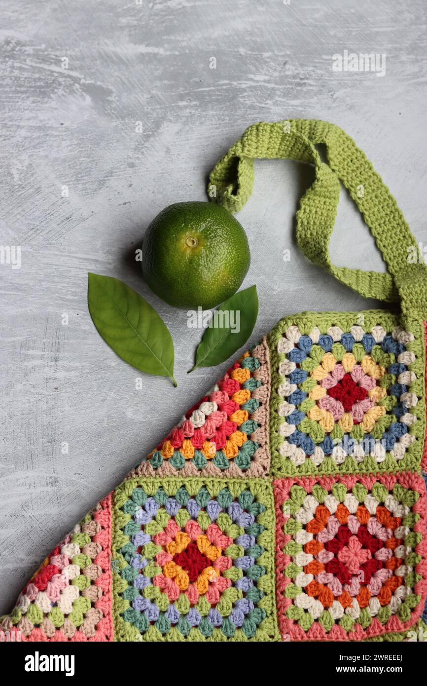Handmade crocheted bag on grey textured background, top view. Close up ...