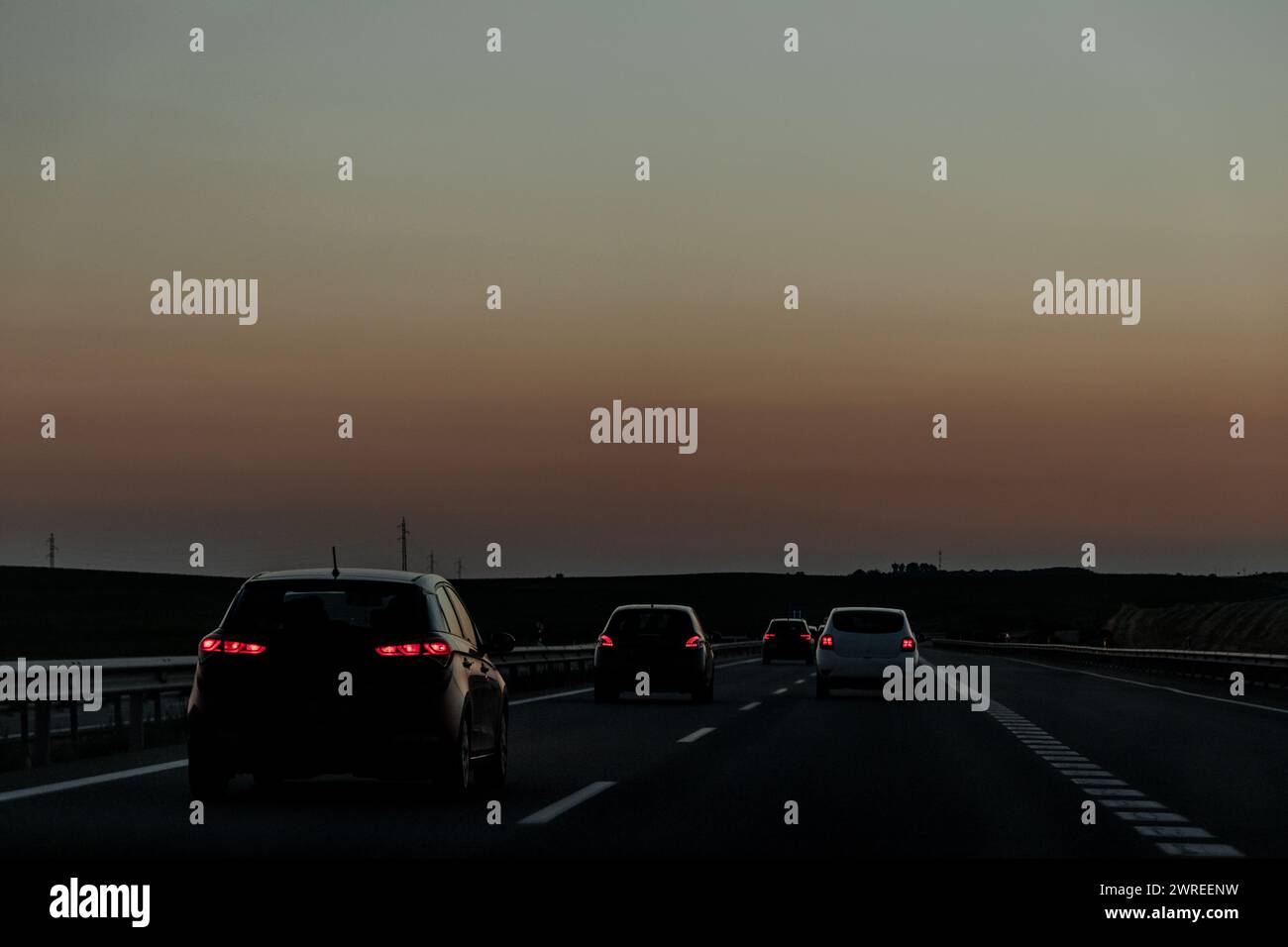 Cars on highway under sunset sky with automotive lighting Stock Photo ...