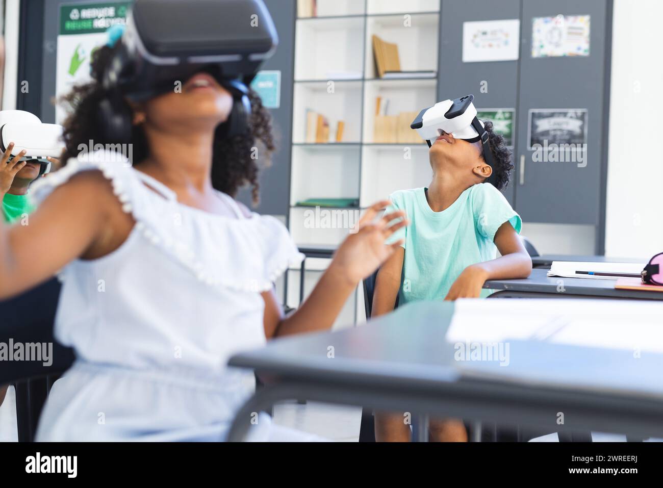 Biracial children are exploring virtual reality in a classroom setting ...