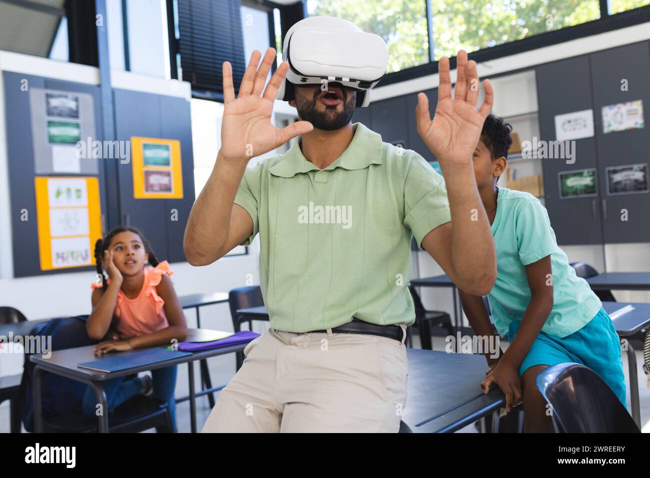 Young Asian male teacher experiences virtual reality, with biracial ...