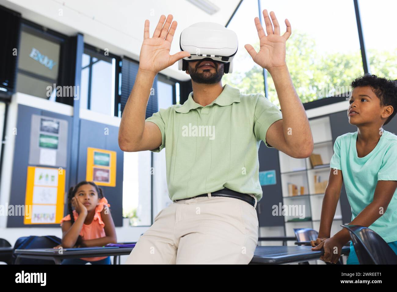 Young Asian male teacher explores virtual reality, wearing a VR headset ...