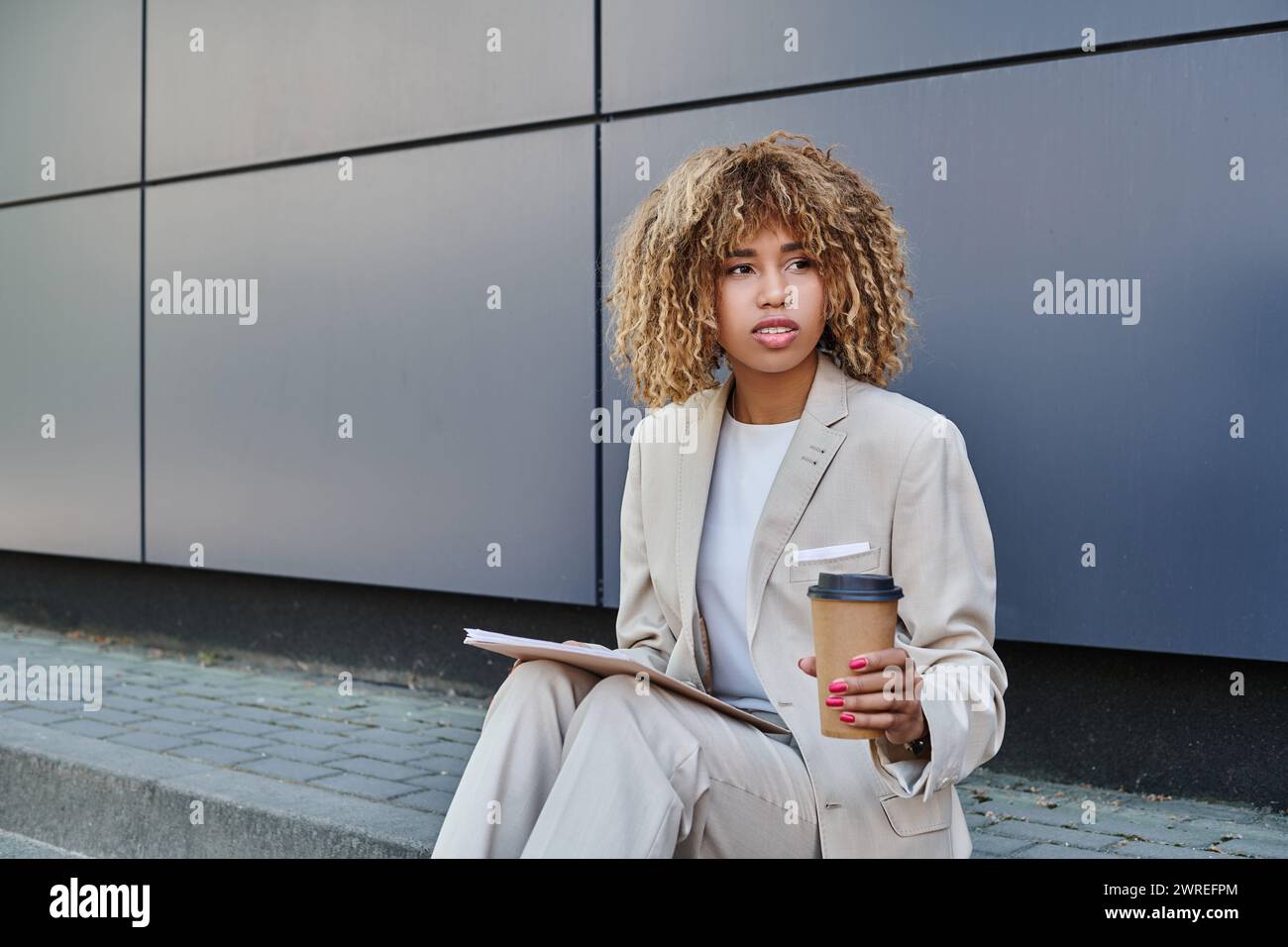 Stylish professional, african american woman with coffee and folder ...