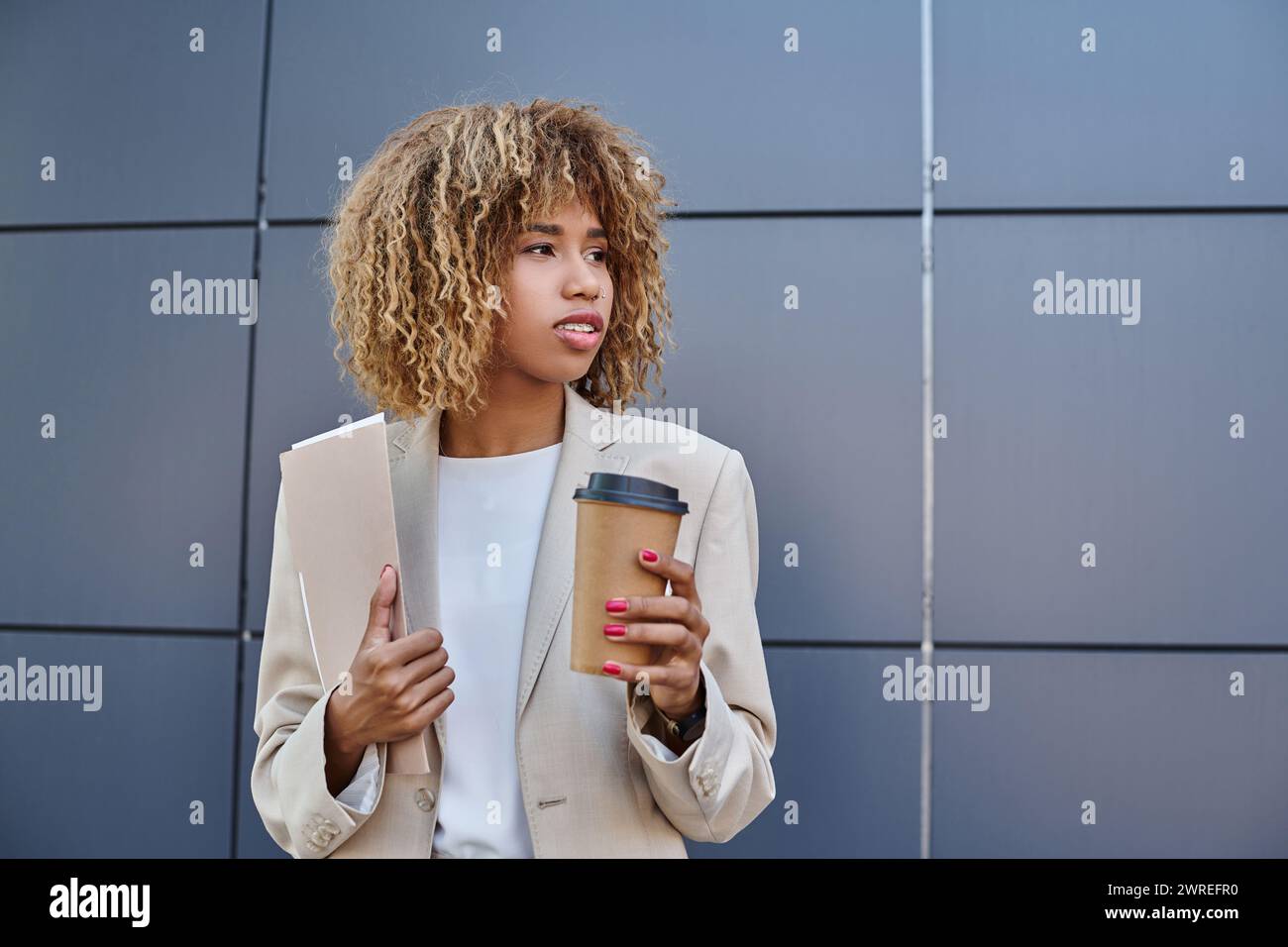Stylish professional, african american woman with coffee and folder ...