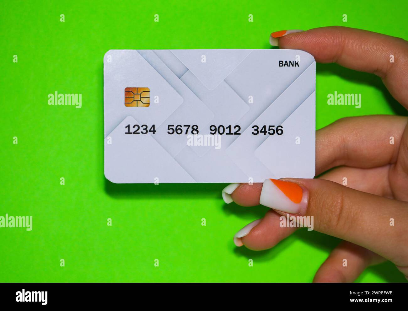 The picture of a white bank card that is held by a young lady in her ...