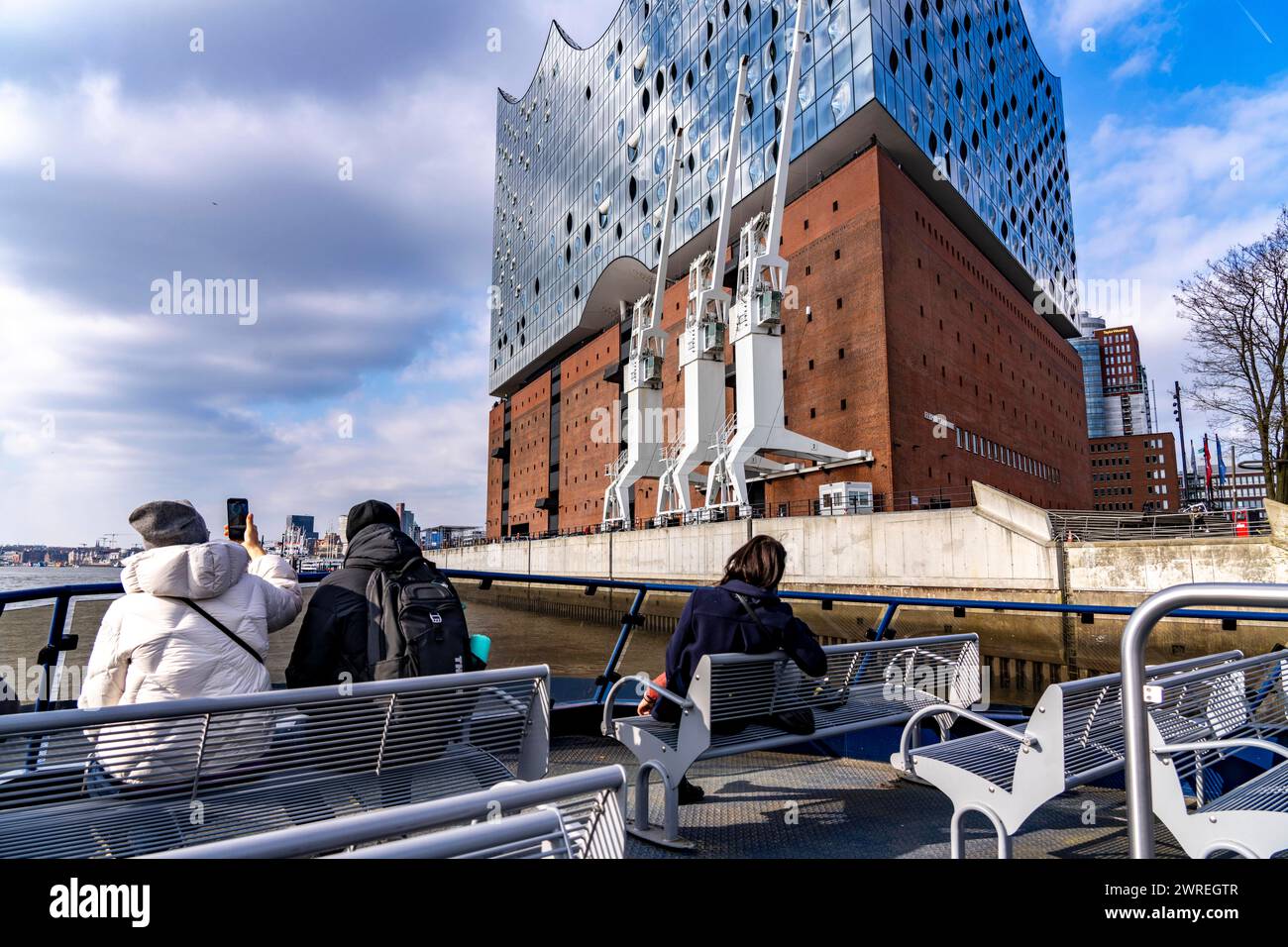 Die Fassade der Elbphilharmonie, Touristen auf einer Hafenfähre ...