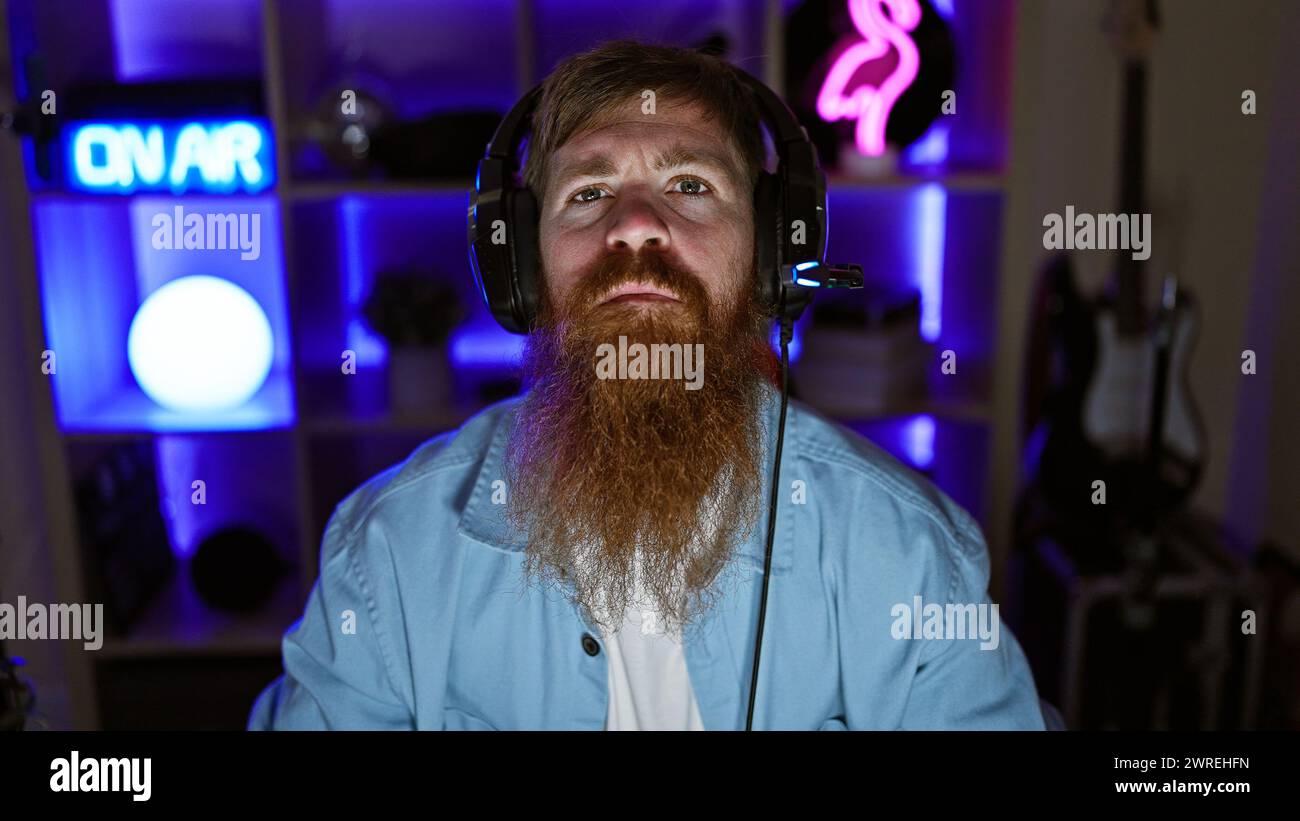 Staunch young redhead man streamer, seriously immersed in digital ...