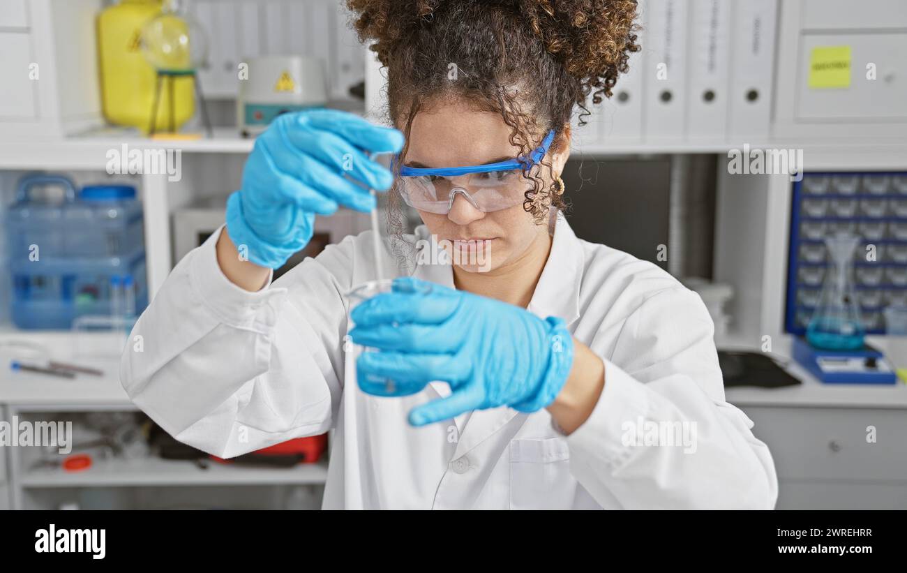A young adult hispanic woman with curly hair conducts an experiment in ...