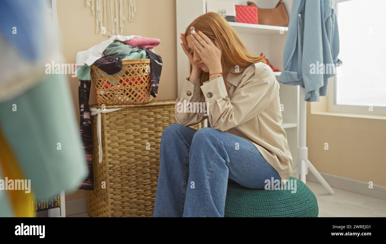 A distressed young woman sits in a cluttered dressing room, covering ...
