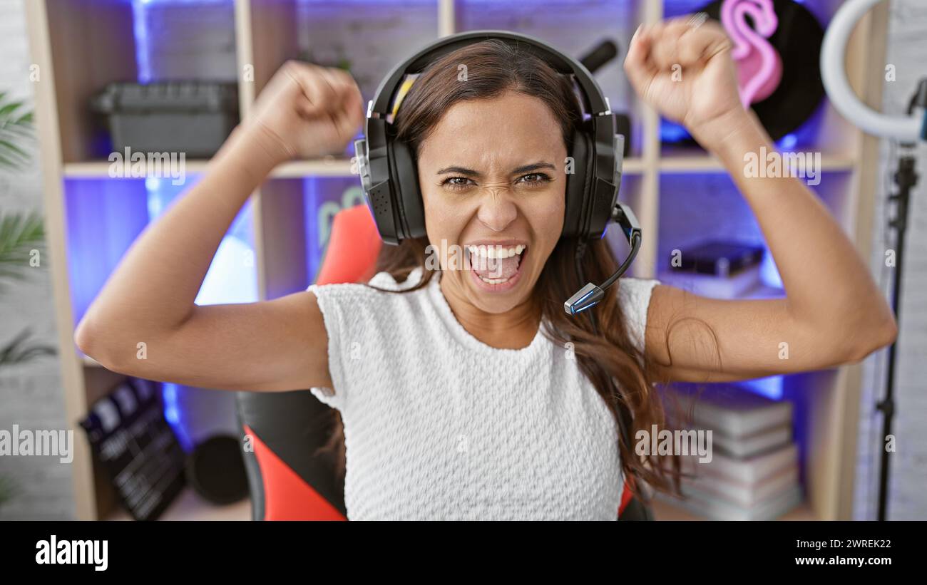 Young beautiful hispanic woman streamer wearing headset celebrating at ...